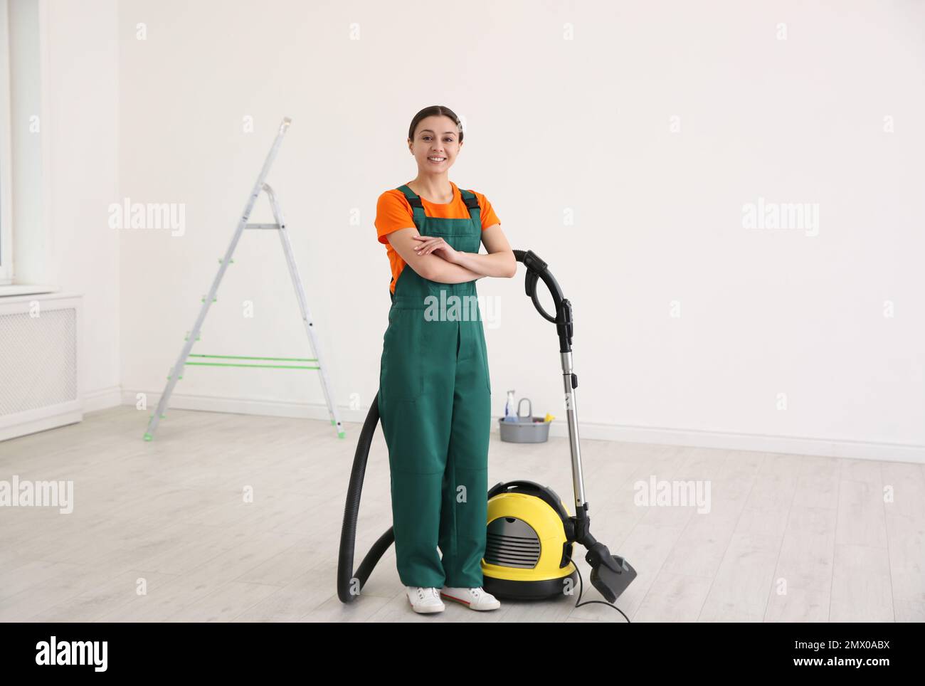 Professional young janitor vacuuming indoors. Cleaning service Stock ...