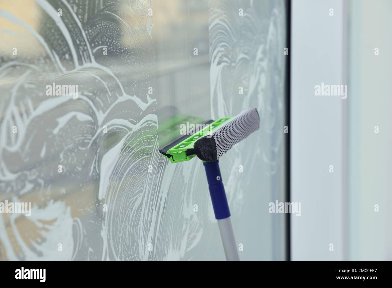 Cleaning window with squeegee indoors. Household chores Stock Photo - Alamy