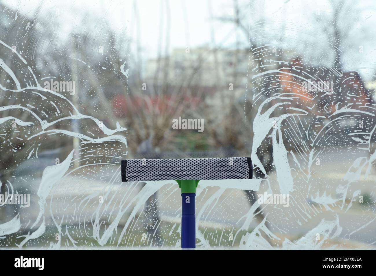 Cleaning window with squeegee indoors. Household chores Stock Photo - Alamy