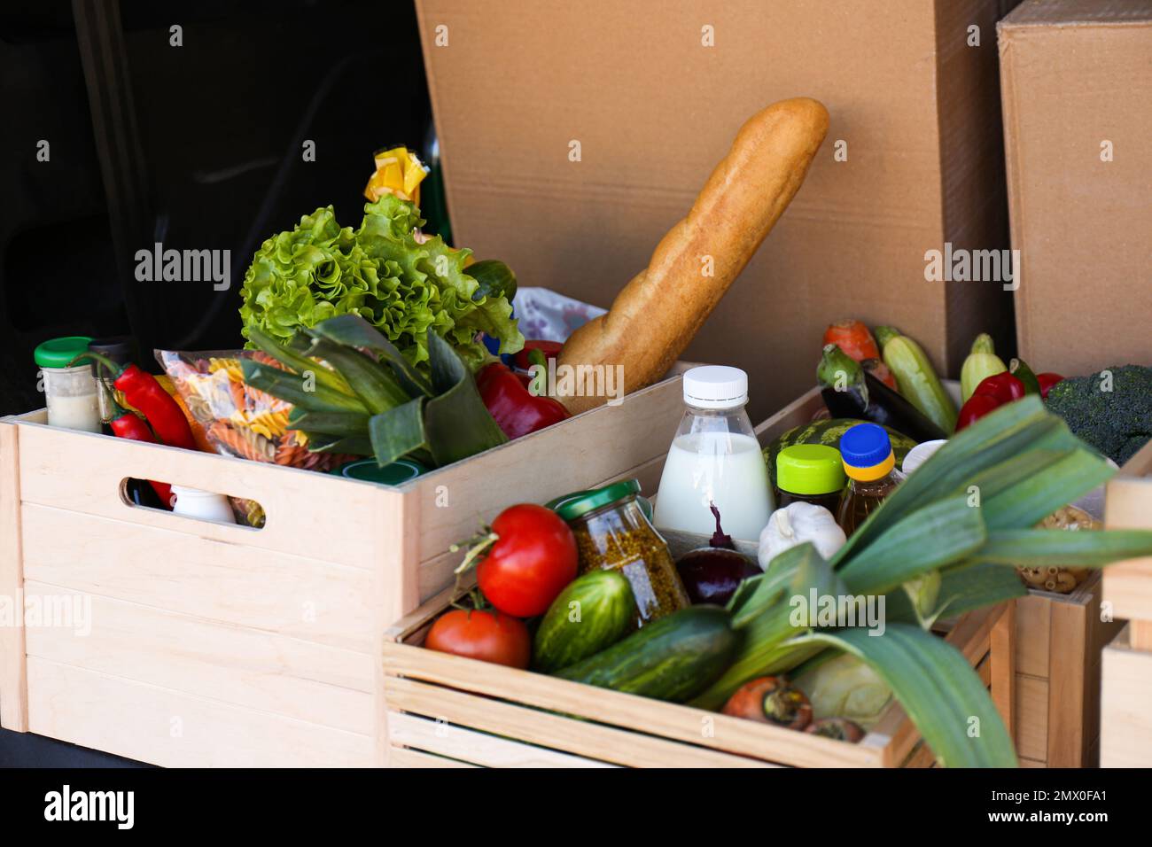 Wooden crates with fresh products in car trunk. Food delivery service ...