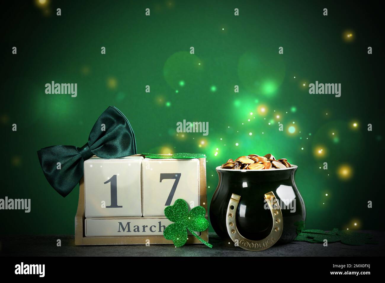Composition with pot of gold coins and wooden block calendar on grey ...