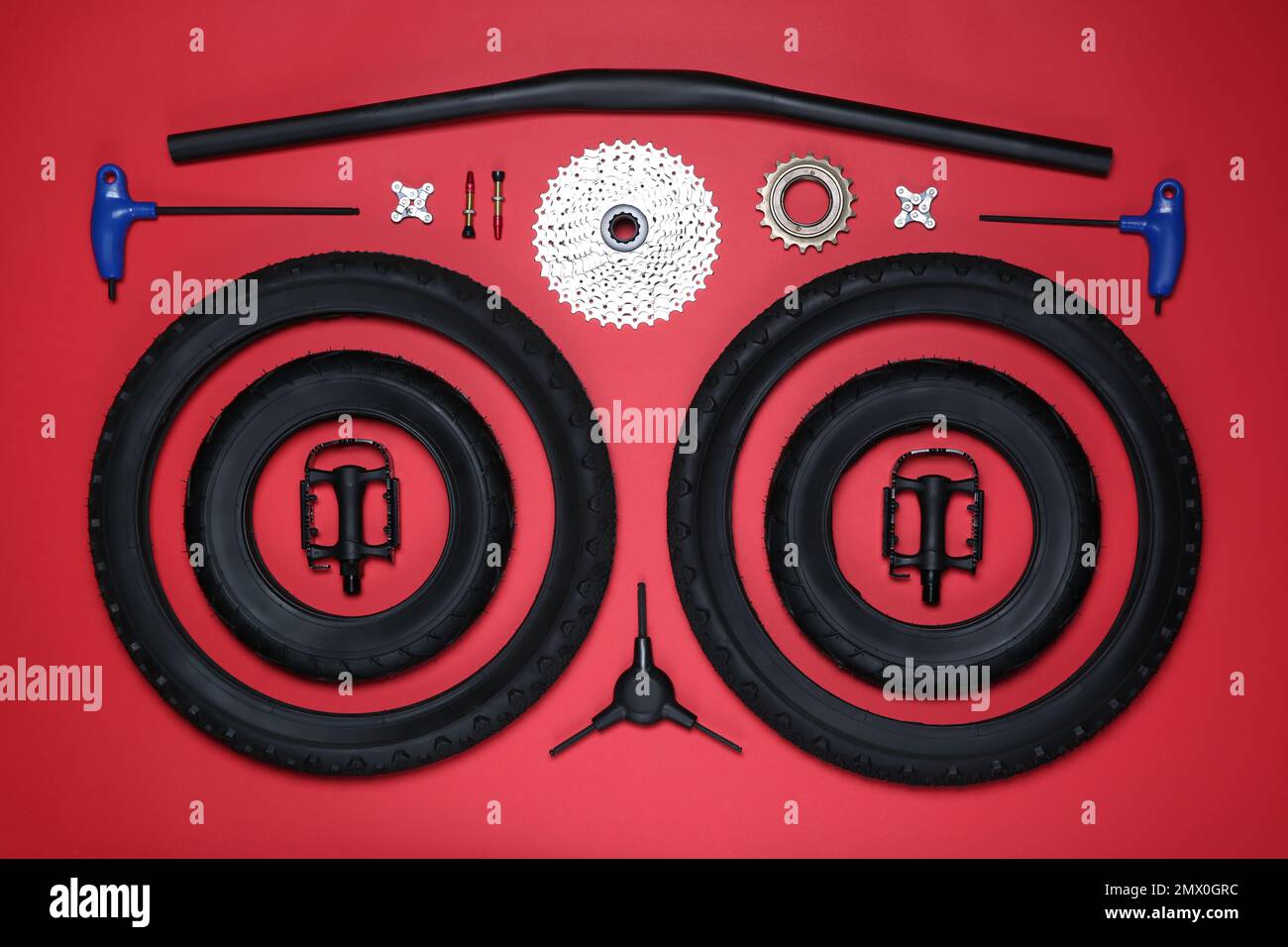 Set of different bicycle tools and parts on red background, flat lay ...