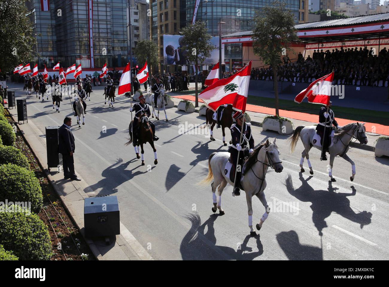 Lebanese Army soldiers ride horses as they carry Lebanese flags during ...