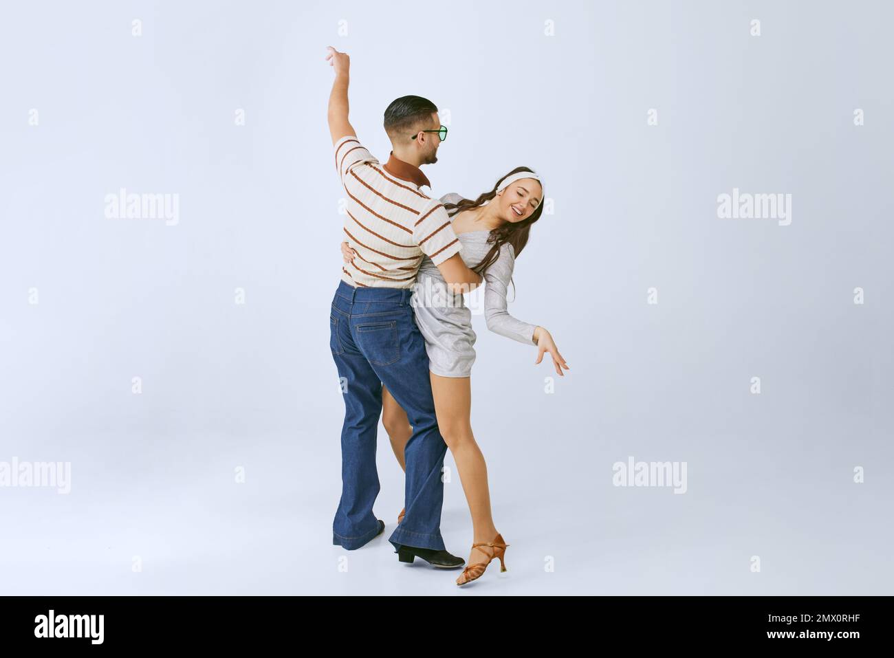Romantic look. Young beautiful girl in silver dress and stylish man ...