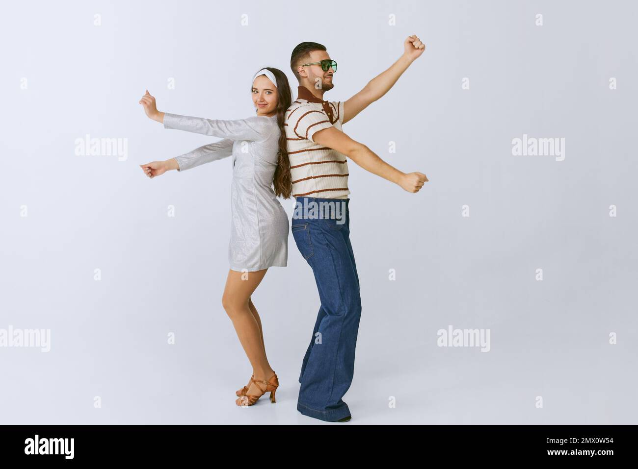 Having fun. Young beautiful girl in silver dress and stylish man ...