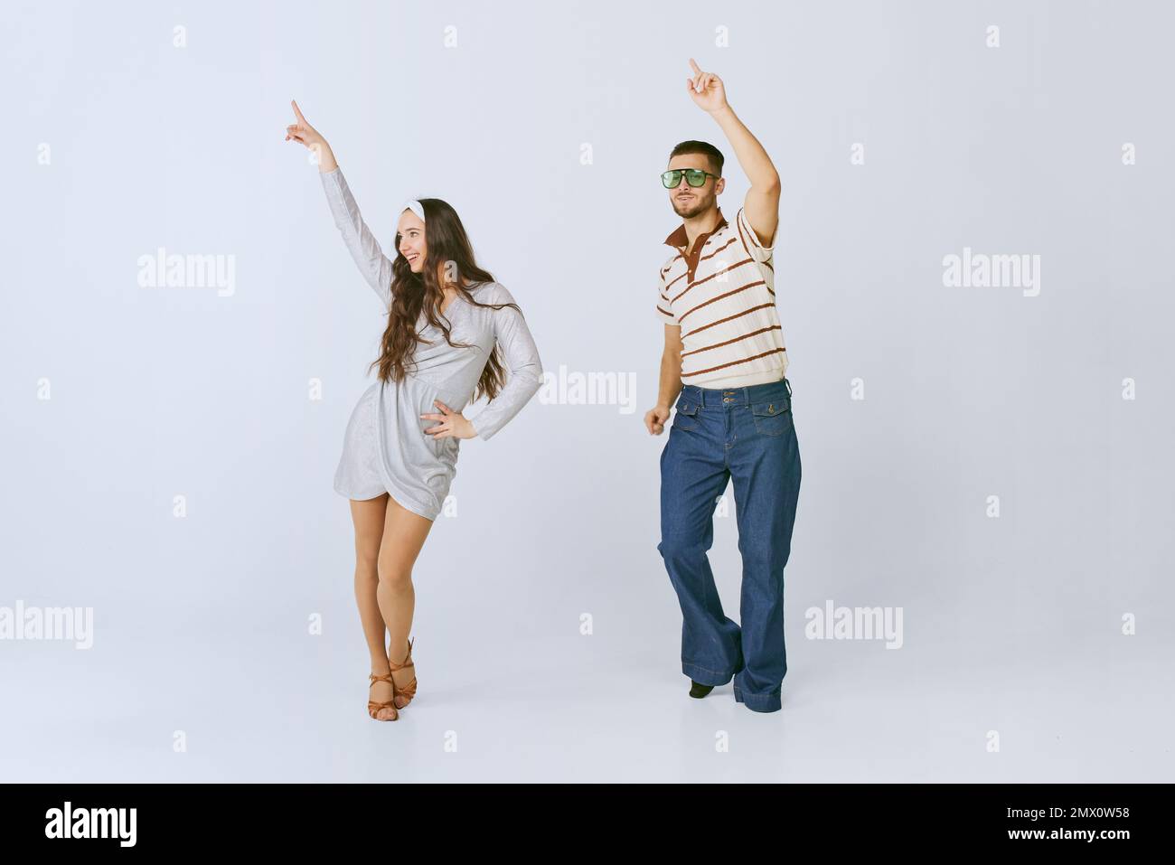 Having fun. Young beautiful girl in silver dress and stylish man ...