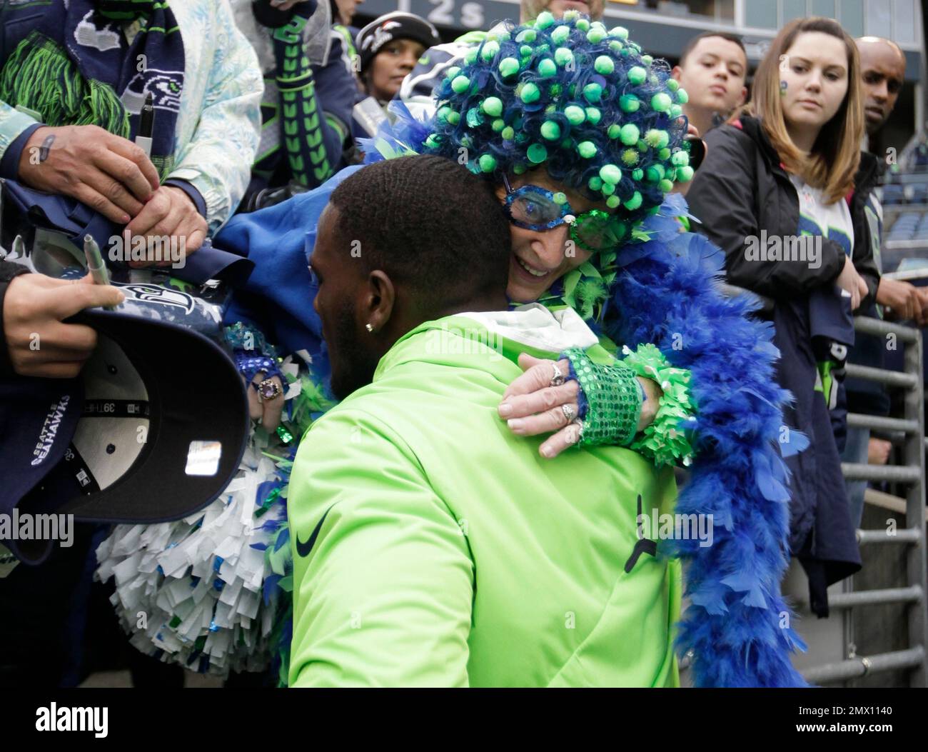 Seattle Seahawks defensive end Frank Clark hugs Seahawks superfan Patti ...