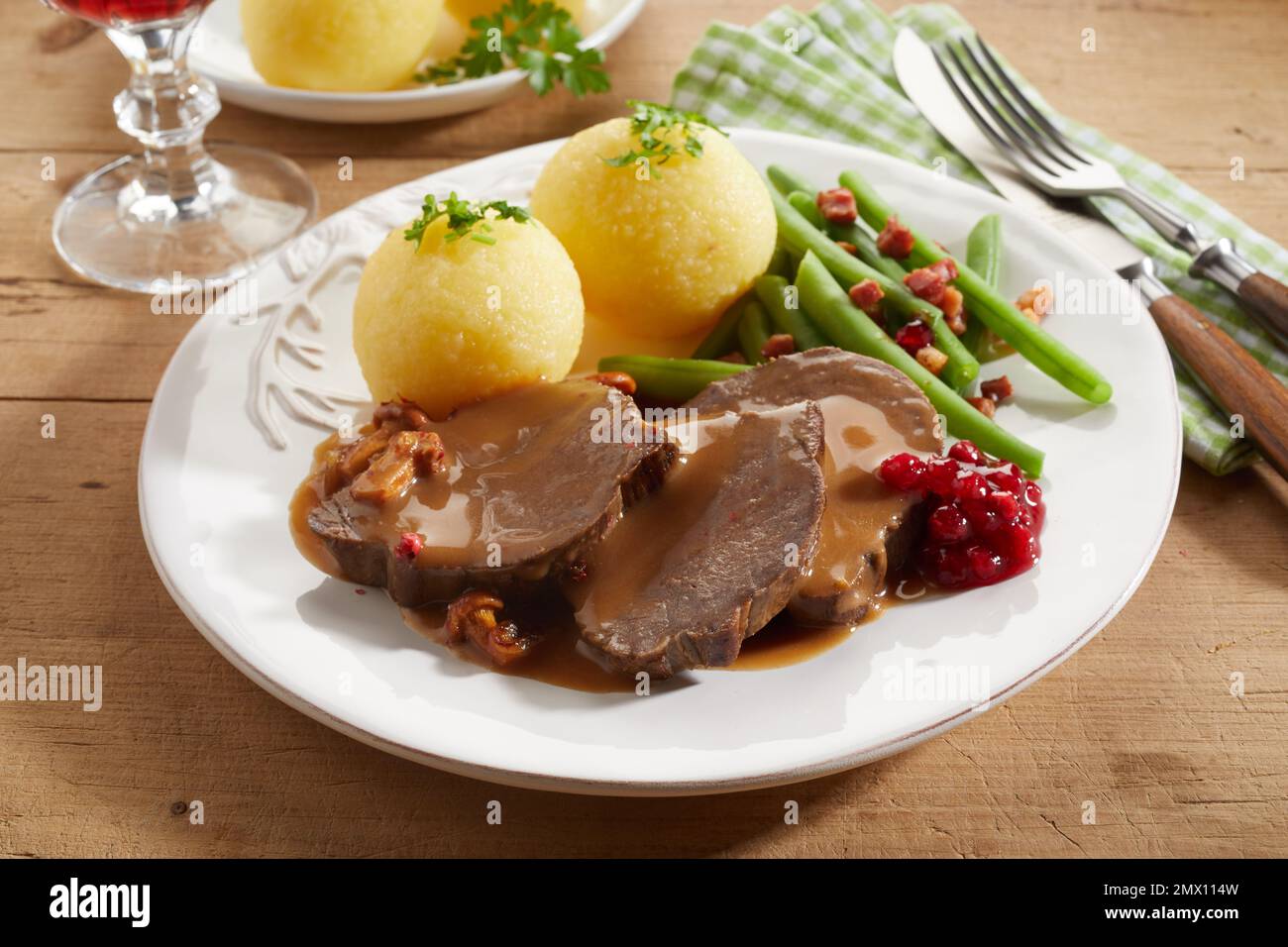 From above slices of roasted deer venison served with cranberry sauce ...
