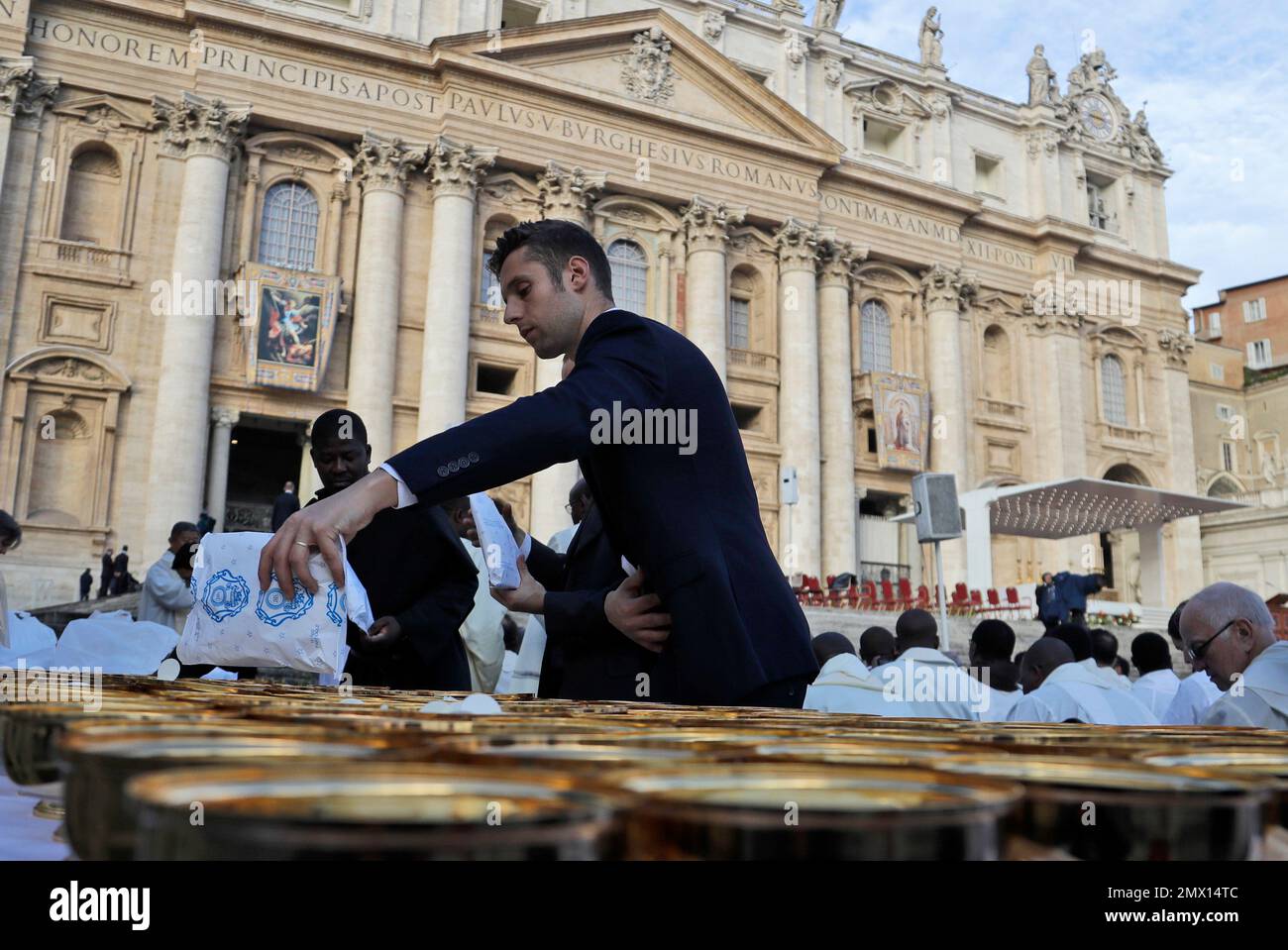 A priest prepares holy hosts before a Mass celebrated by Pope Francis ...
