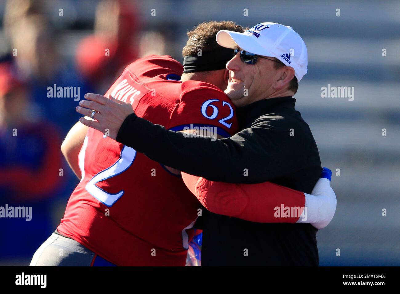 Kansas senior offensive lineman D'Andre Banks (62) hugs head coach ...