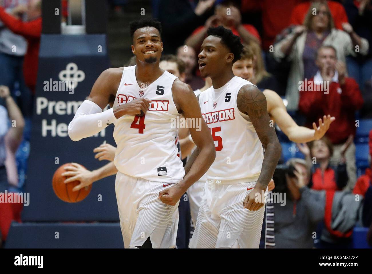 Dayton's Charles Cooke (4) reacts after scoring alongside Dayton's John ...
