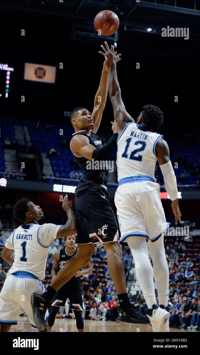 Cincinnati's Kyle Washington, center, shoots over Rhode Island's Hassan ...
