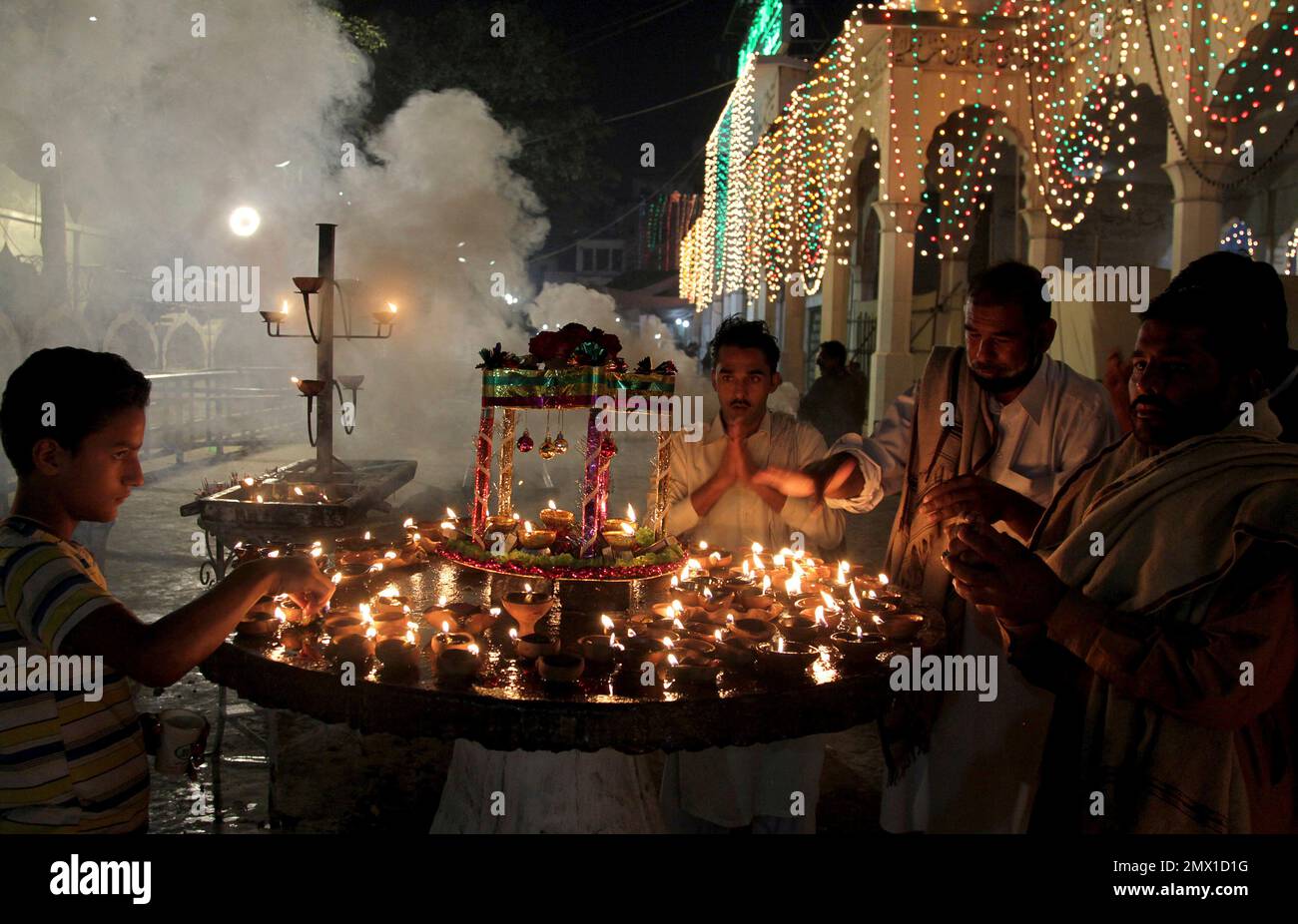 Pakistani devotees light clay-lamps during the celebrations of the ...