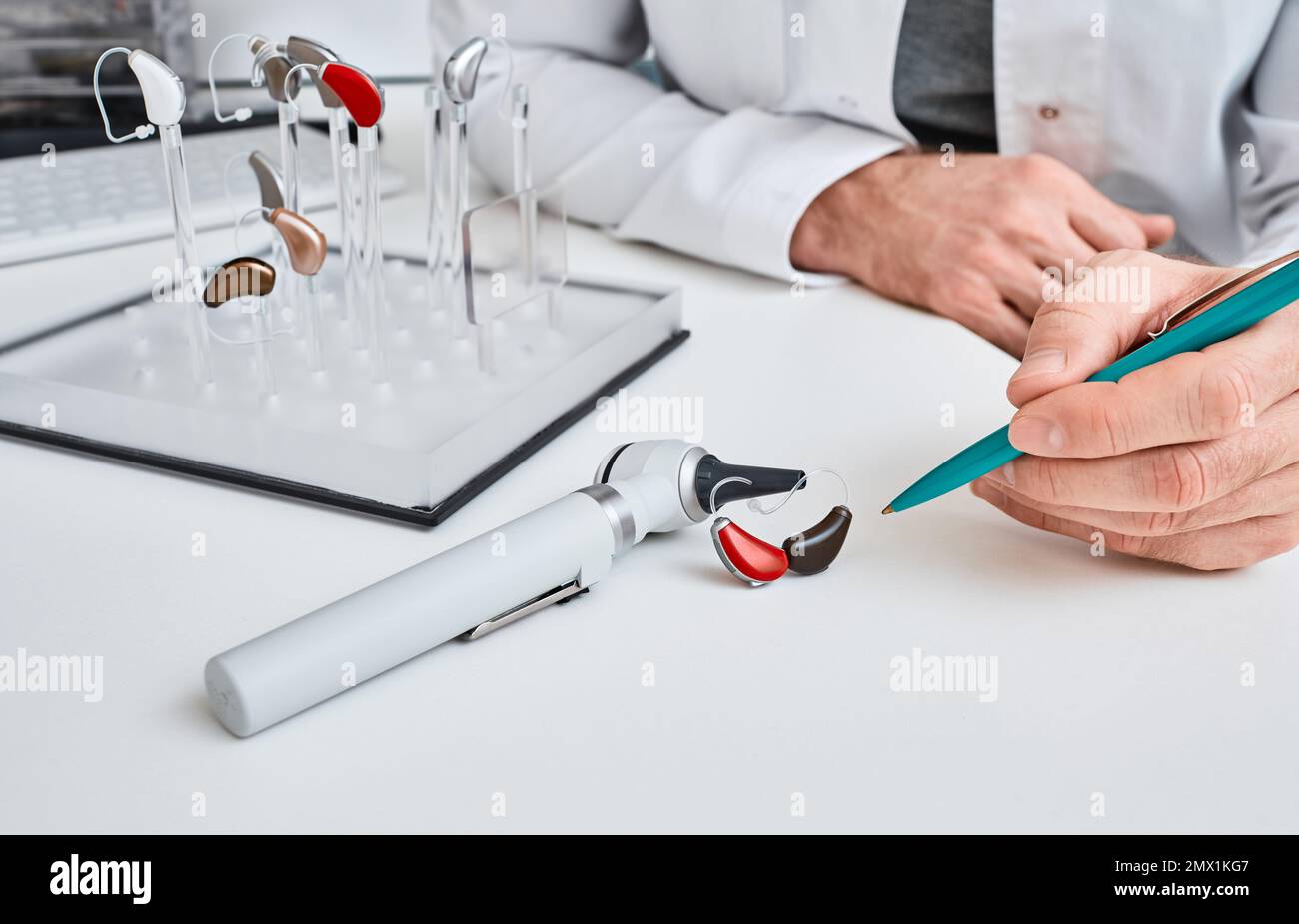 Audioprosthetist presentation hearing aids in two colors to his patient ...