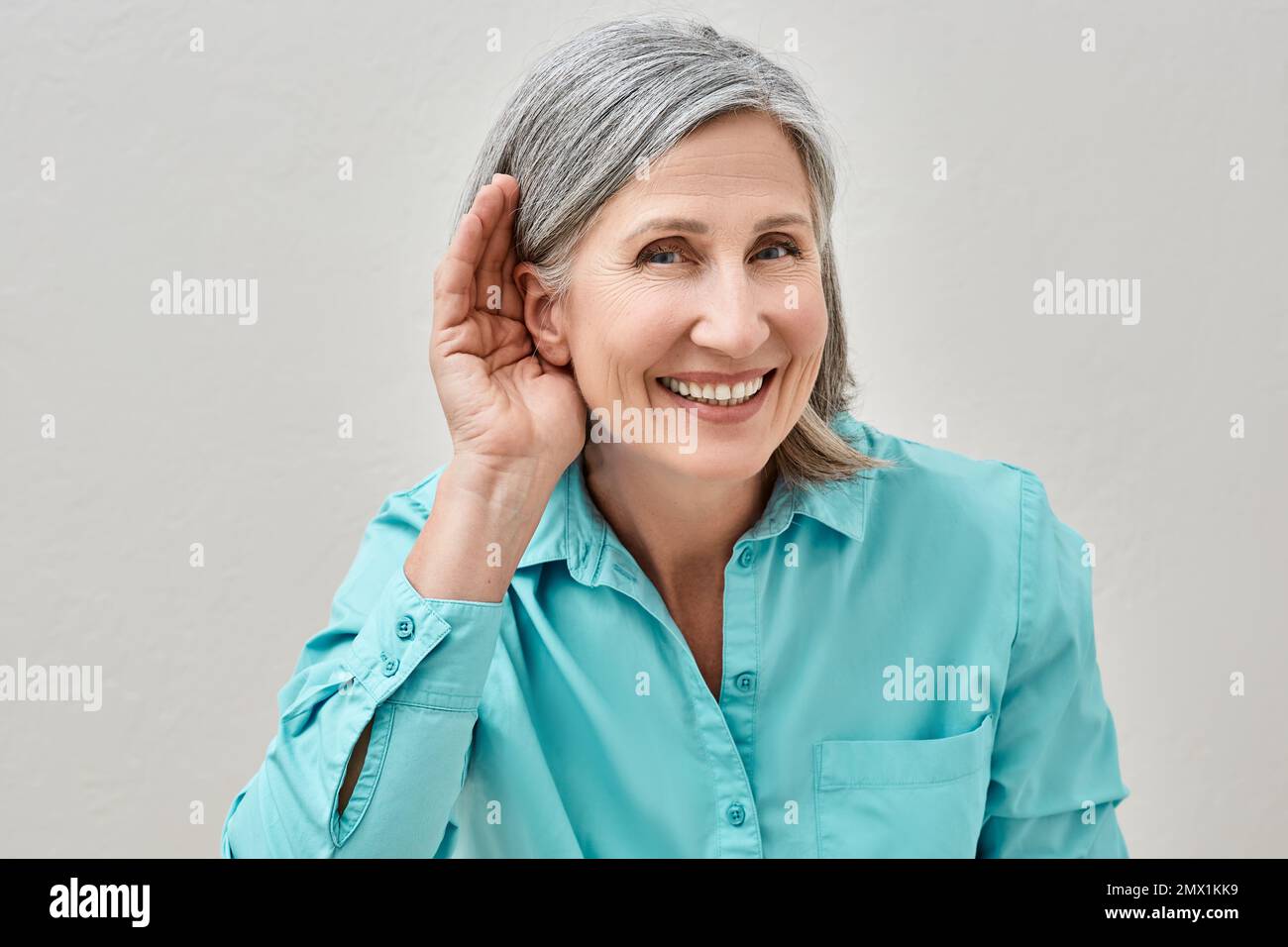Mature woman listening sound with hand near ear for hearing check-up ...