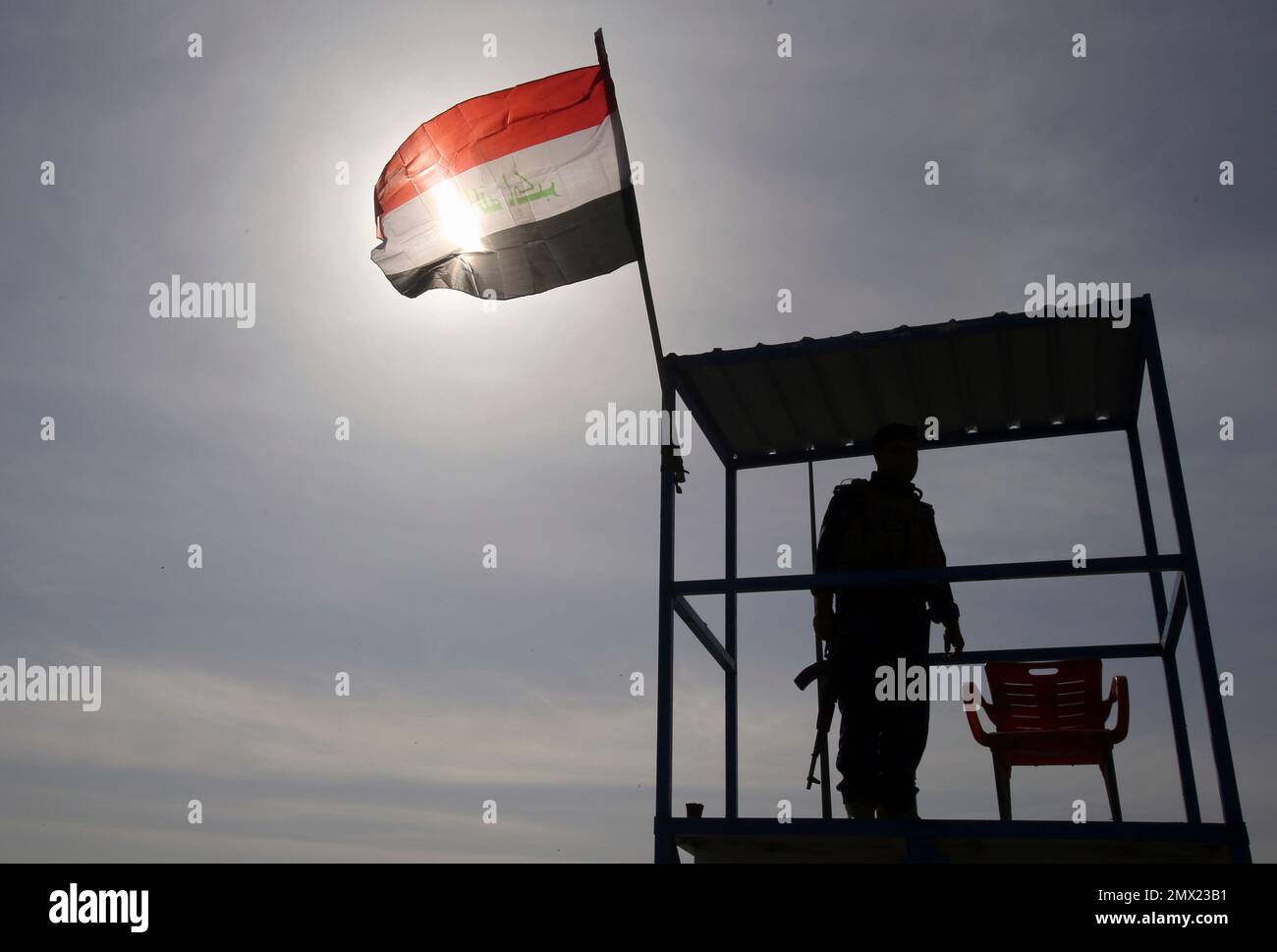 An Iraqi policeman stands guard on a watchtower as Shiite pilgrims ...