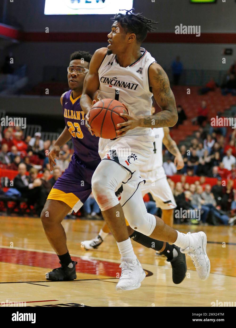 Cincinnati guard Jacob Evans (1) drives to the basket against Albany ...