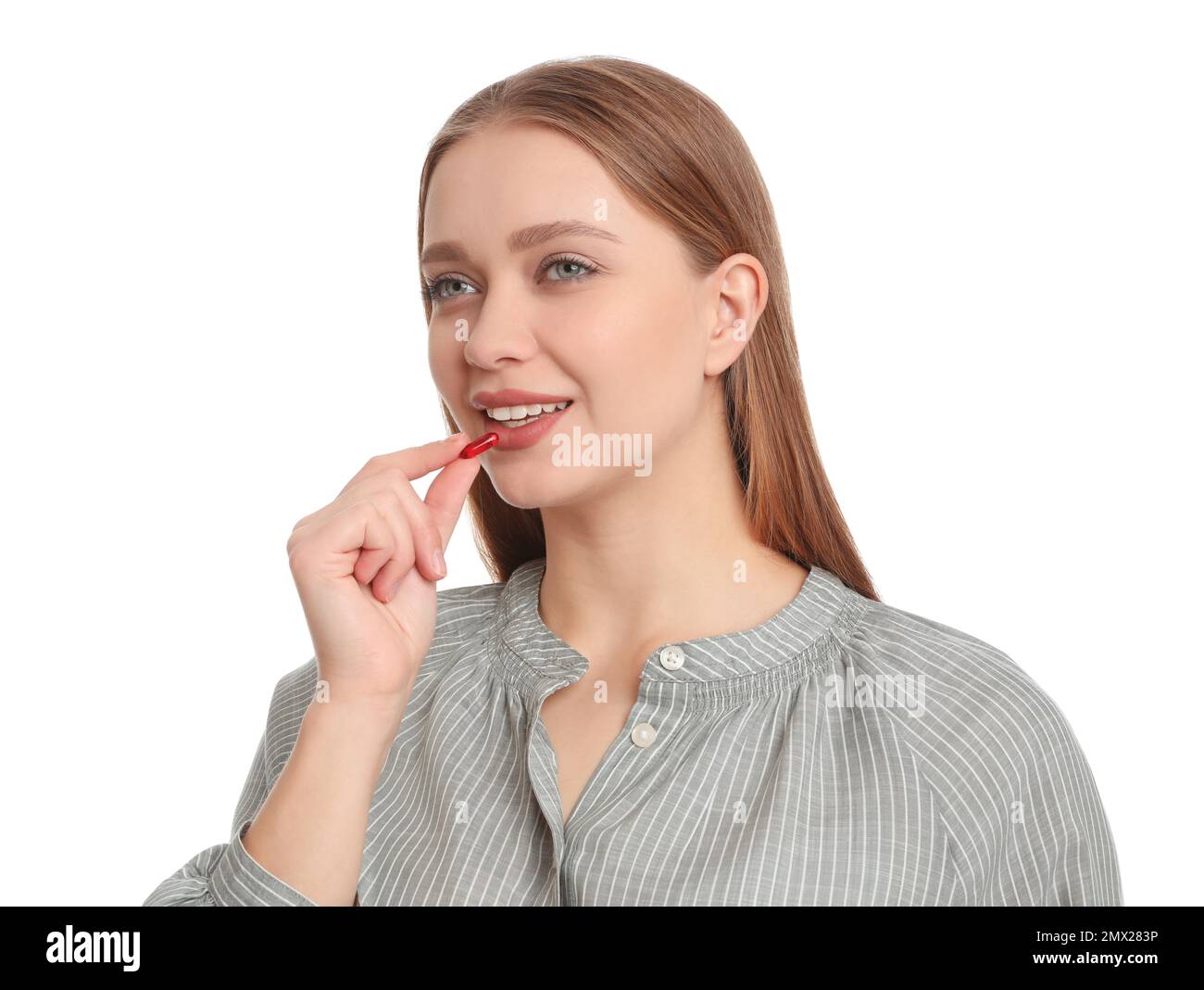 Young woman taking vitamin capsule on white background Stock Photo - Alamy