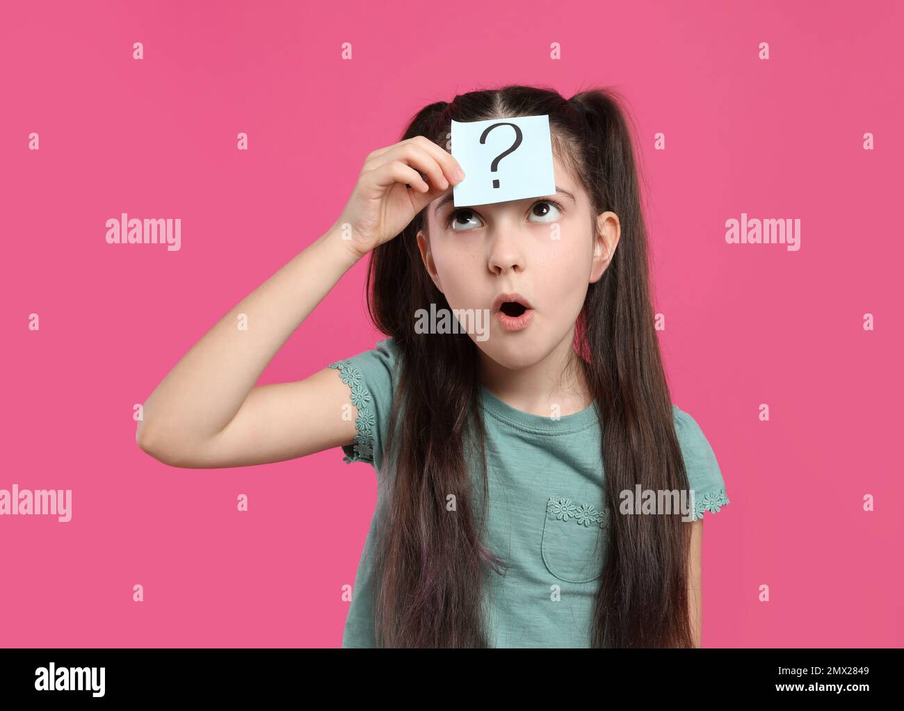 Emotional girl with question mark sticker on forehead against pink ...
