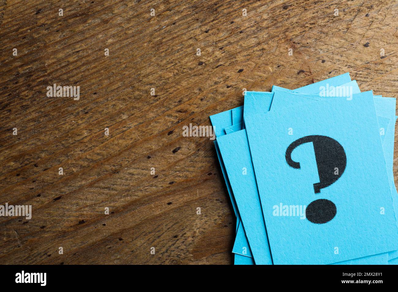 Blue paper cards with question mark on wooden background, top view ...