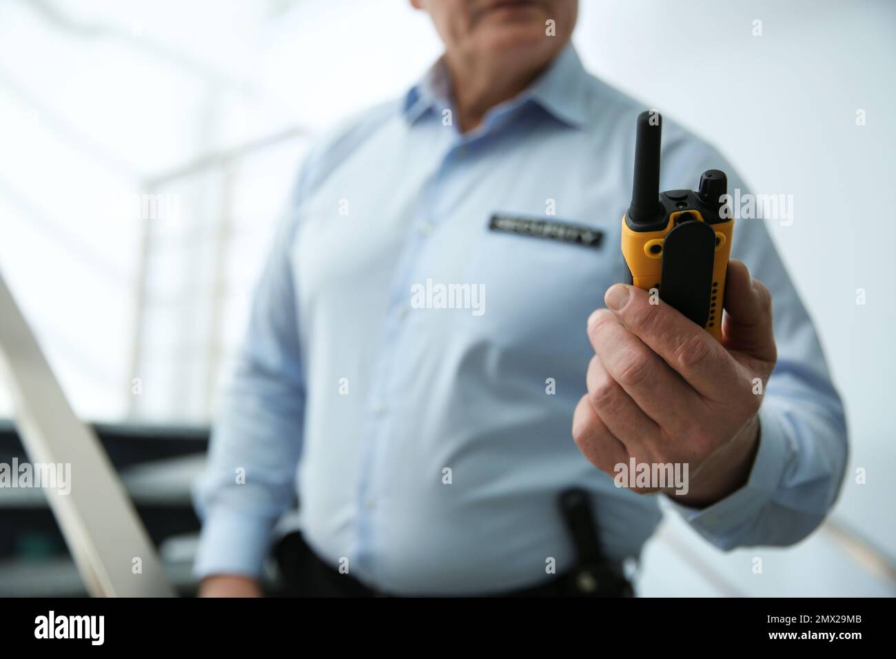 Professional security guard with portable radio set on stairs, closeup ...