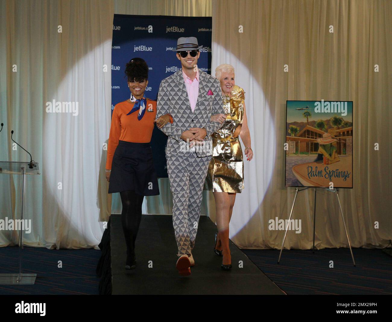 A JetBlue's crew member and models wearing Trina Turik designs walks ...