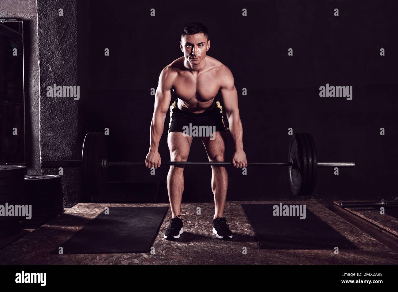 Strong man lifting barbell in modern gym Stock Photo - Alamy