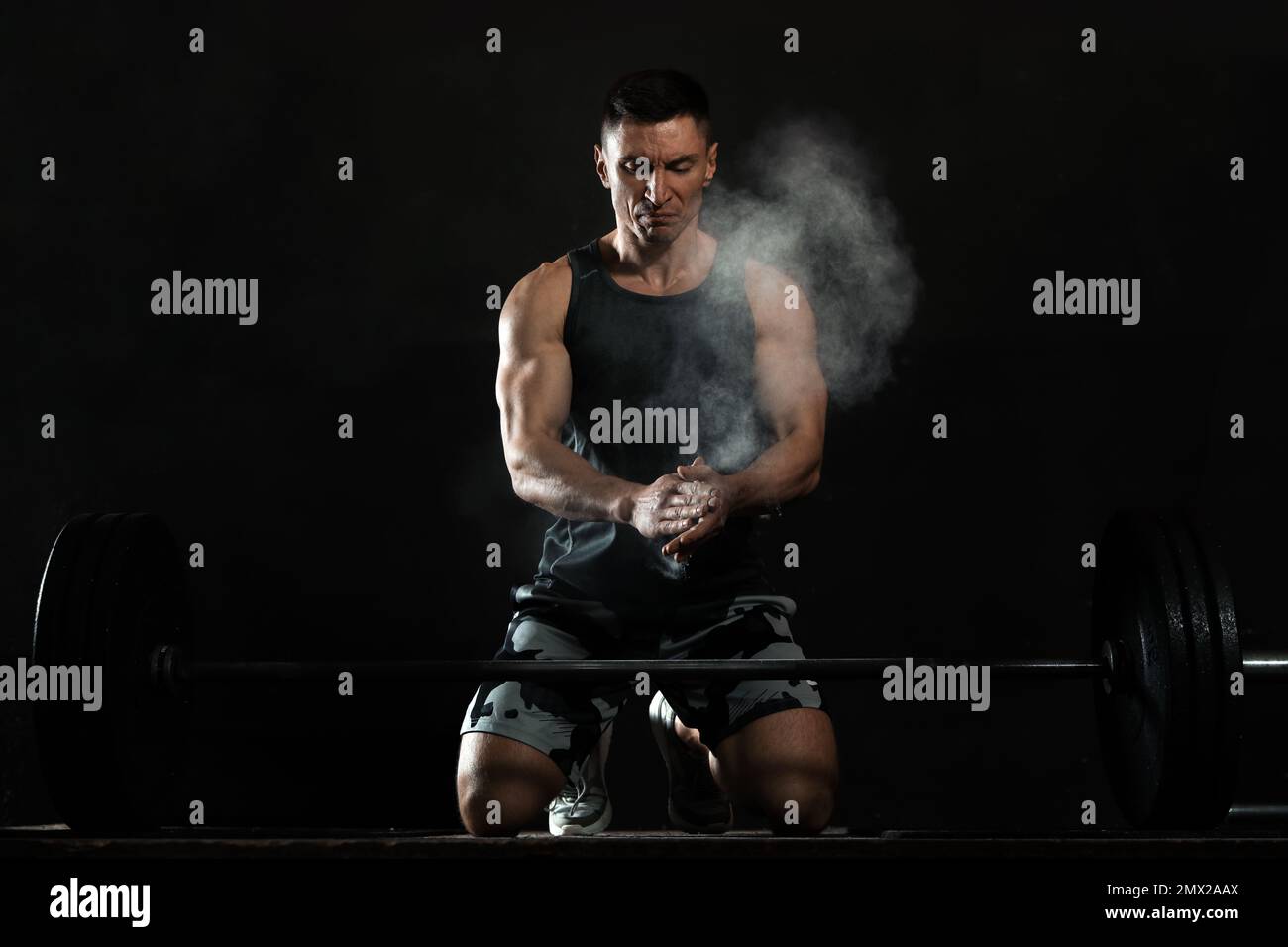 Strong man applying magnesium powder on hands before training with ...