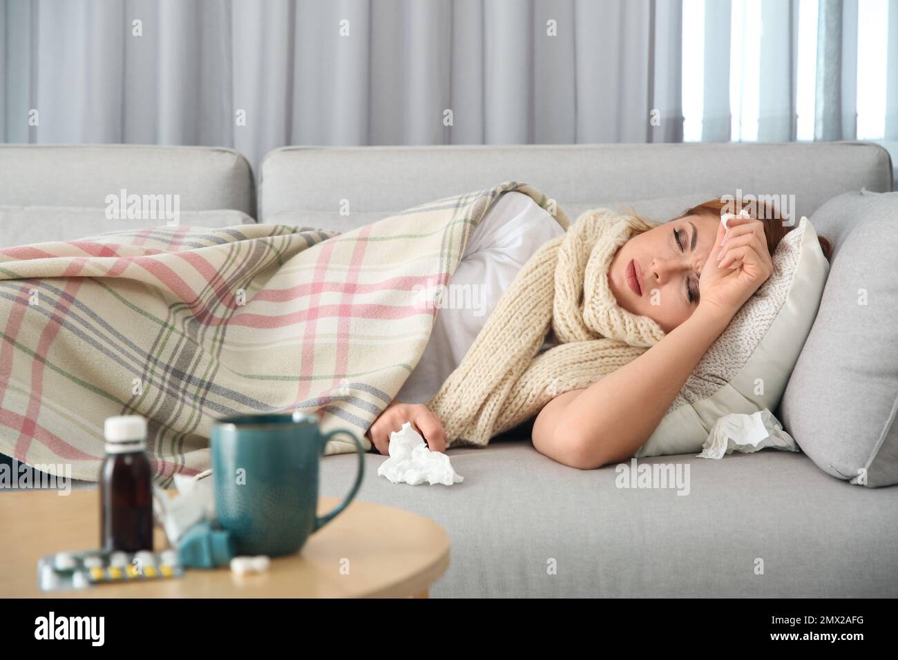 Sick woman lying on sofa at home. Influenza virus Stock Photo - Alamy