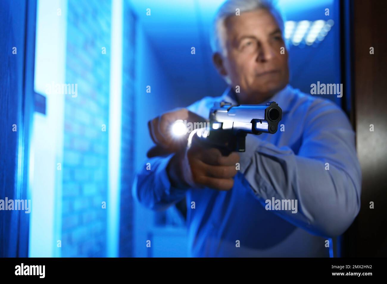 Professional security guard with gun checking dark room, focus on hand ...