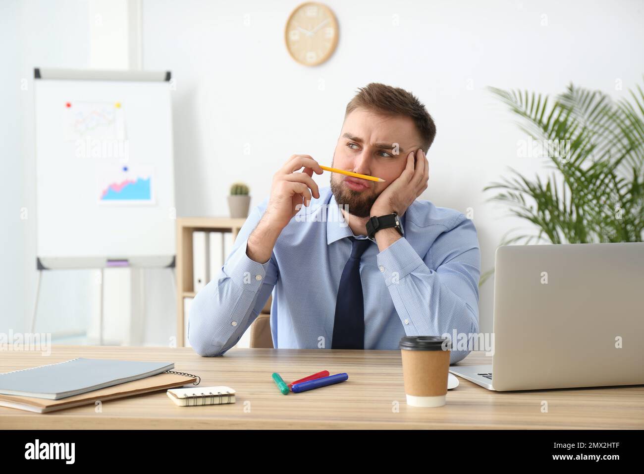 Lazy young office employee procrastinating at workplace Stock Photo - Alamy