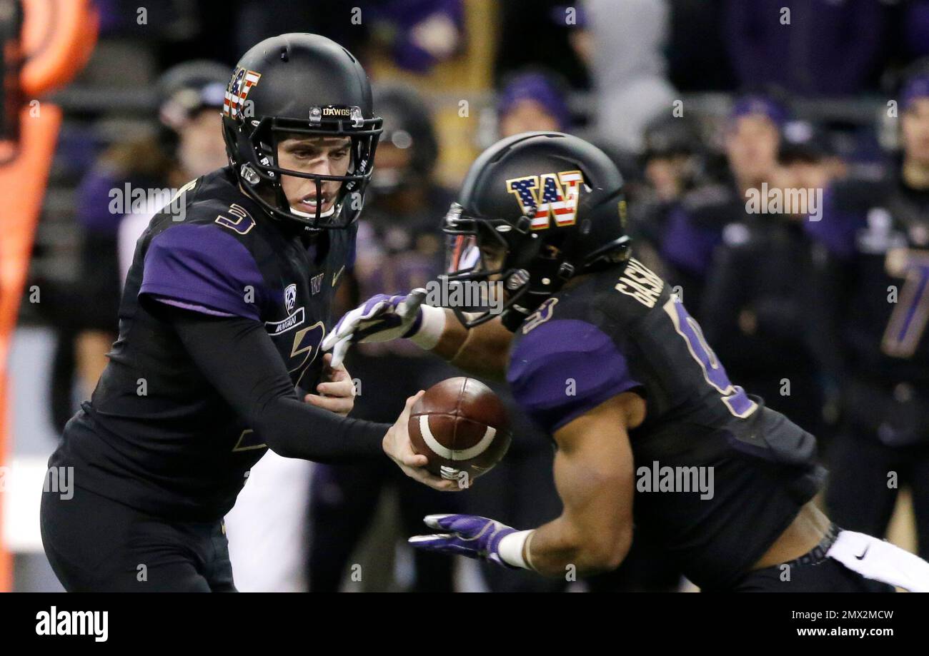 Washington quarterback Jake Browning, left, hands off to Washington ...
