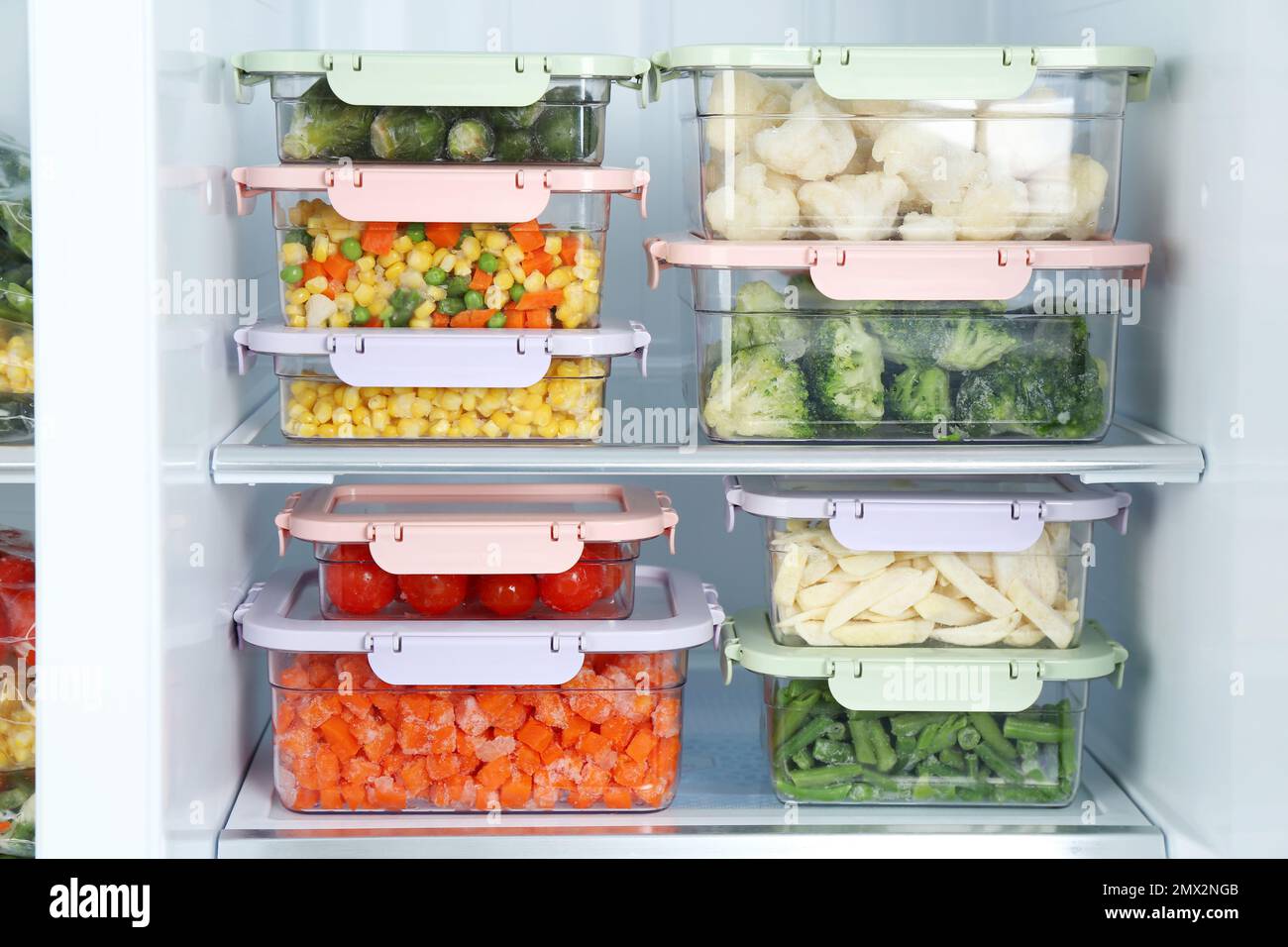 Containers with different frozen vegetables in refrigerator Stock Photo ...