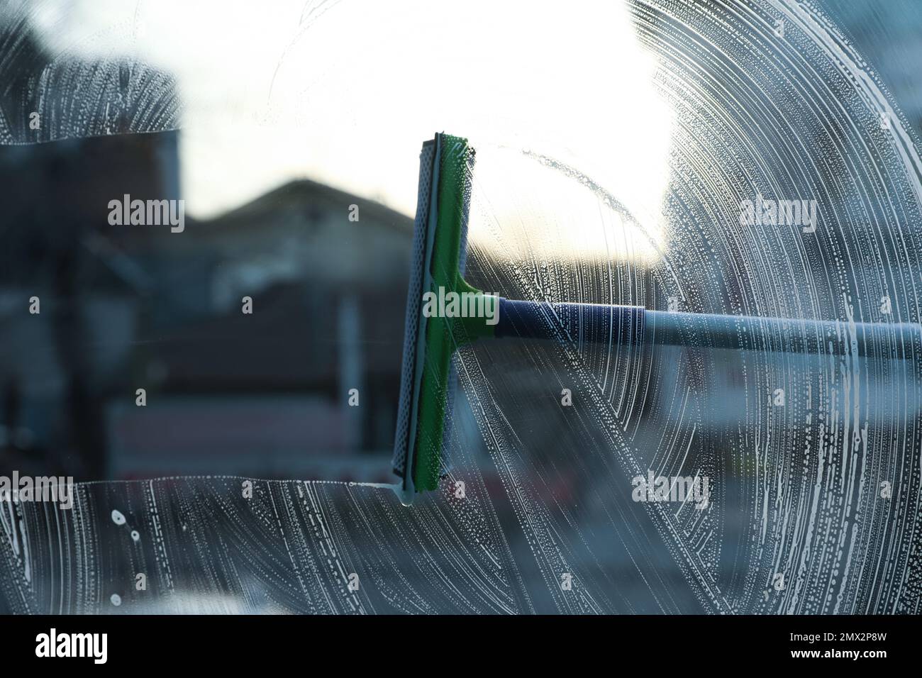 Cleaning window with squeegee indoors. Household chores Stock Photo - Alamy
