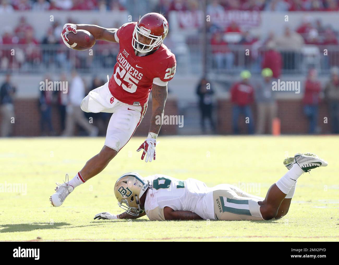 Oklahoma running back Joe Mixon (25) leaps over Baylor cornerback Ryan ...