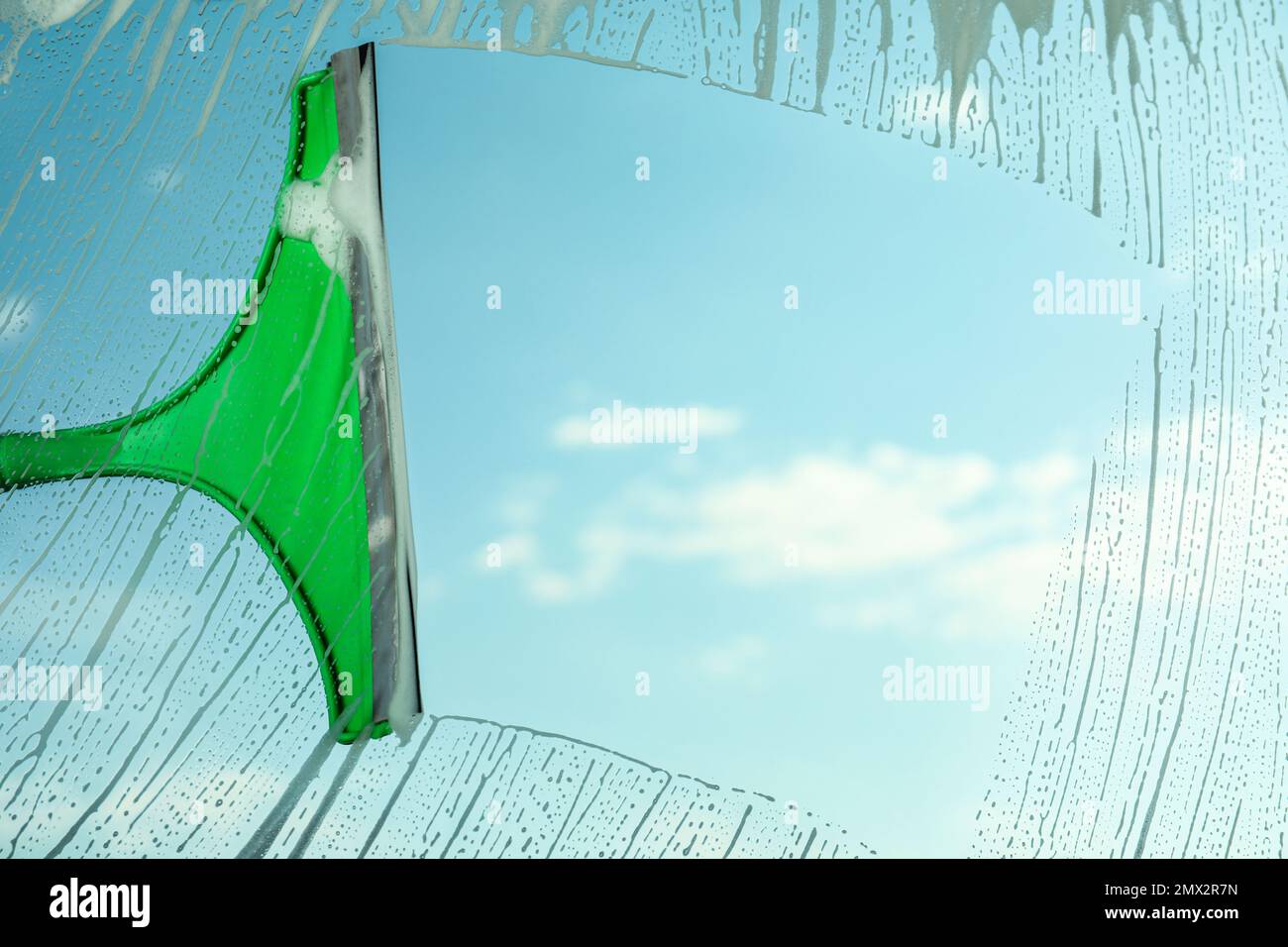 Cleaning window with squeegee on spring day Stock Photo - Alamy