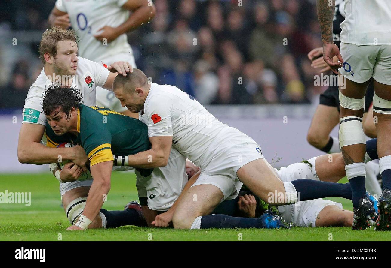 South Africa's Francois Venter, centre, is tackled by England's Mike ...