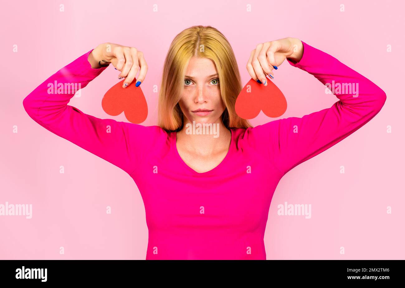 Valentines Day. Sad blonde woman with two red paper hearts. Unhappy ...