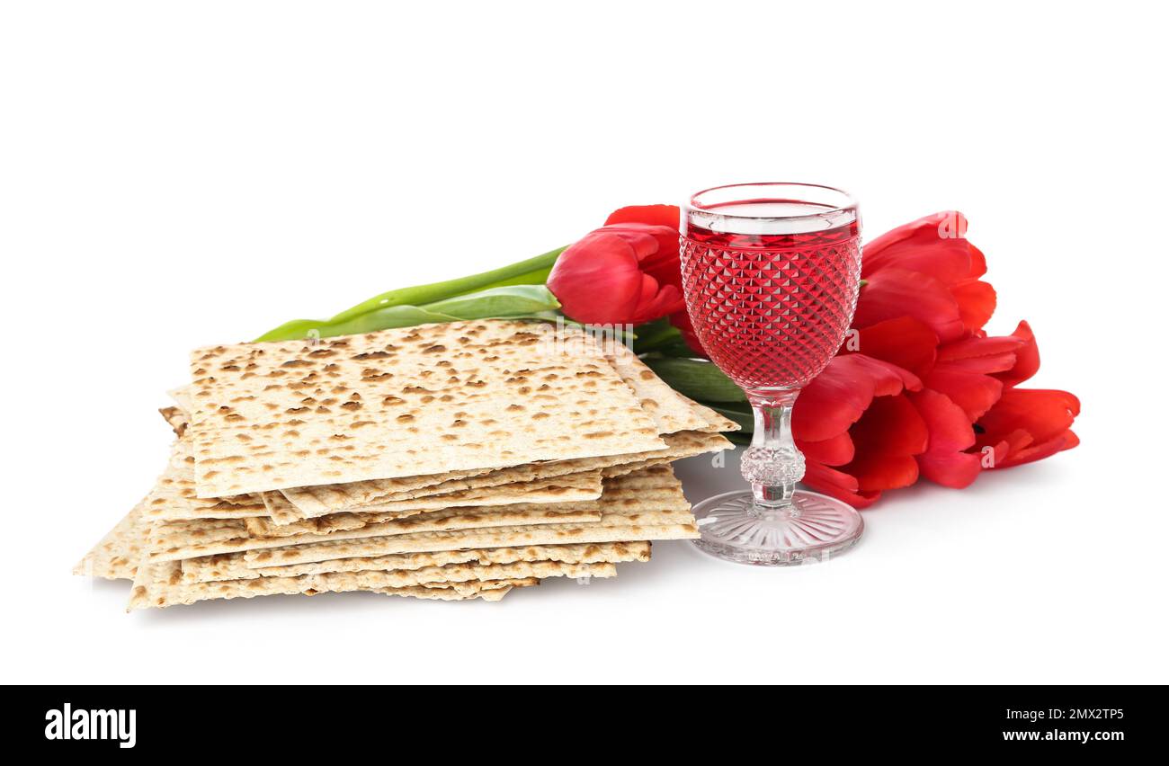 Passover matzos, glass of wine and flowers on white background. Pesach ...