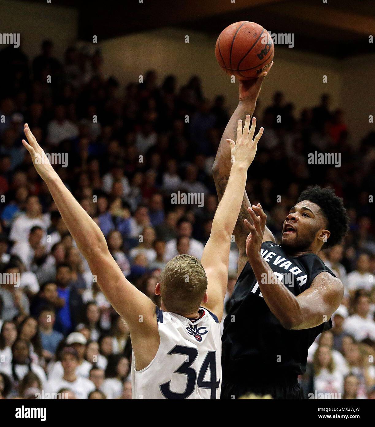 Nevada's Elijah Foster, right, shoots over Saint Mary's Jock Landale ...