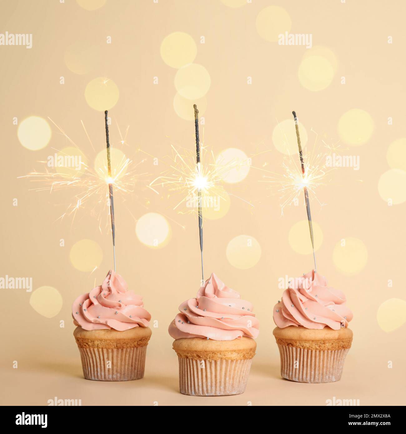 Birthday cupcakes with sparklers on beige background Stock Photo - Alamy