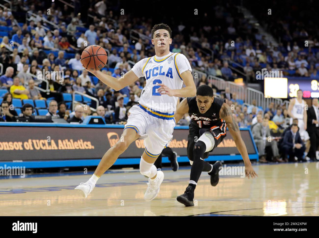 UCLA's Lonzo Ball, center, drives to the basket past Pacific's D.J ...