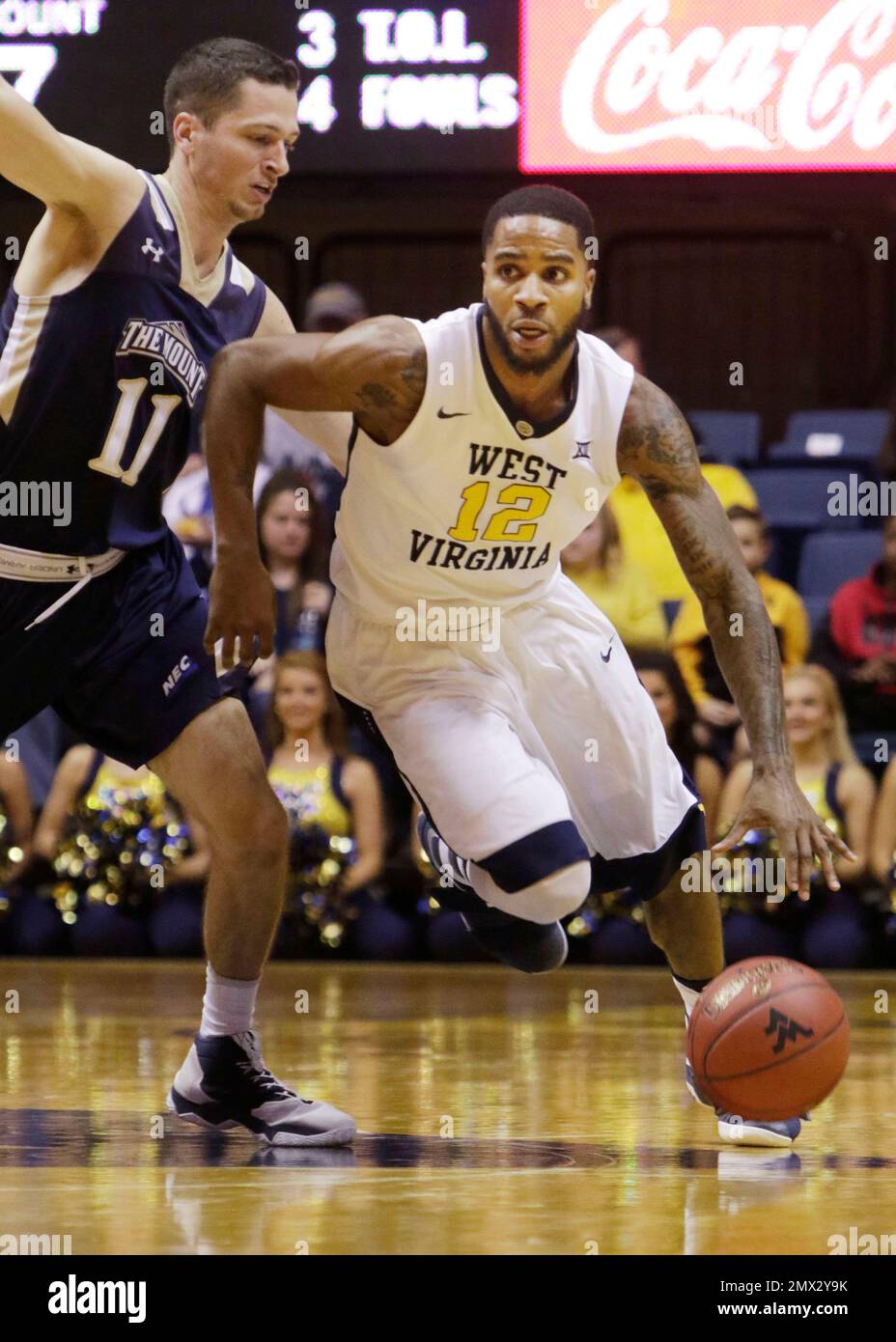 West Virginia guard Tarik Phillip (12) drives pass Mount St. Mary's ...