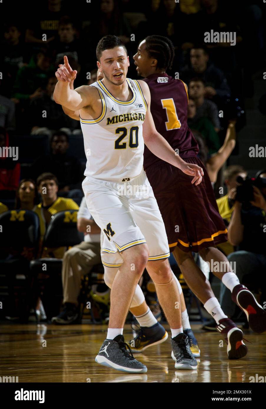 Michigan forward Sean Lonergan (20) points on the court between baskets ...