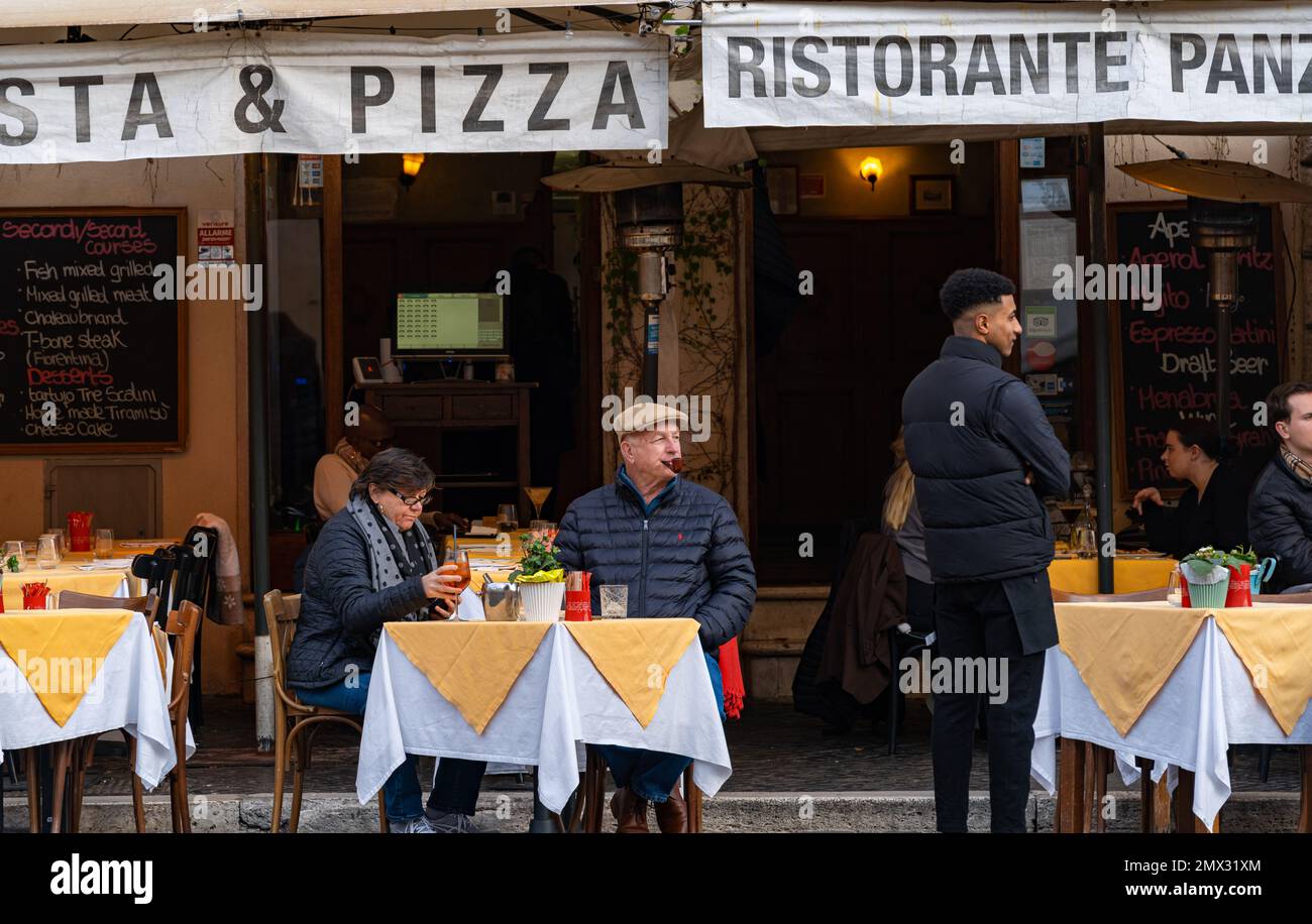adult couple sitting making an aperitif in a typical traditional Roman ...