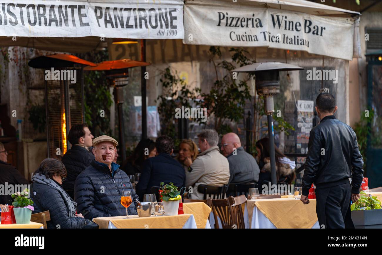 group of people drinking a drink sitting outside a traditional Roman ...