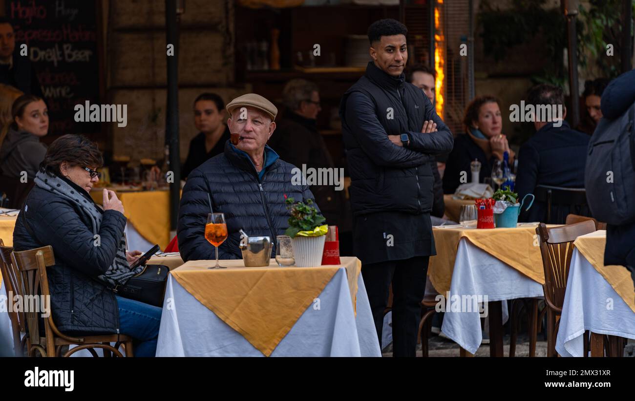 group of people drinking a drink sitting outside a traditional Roman ...