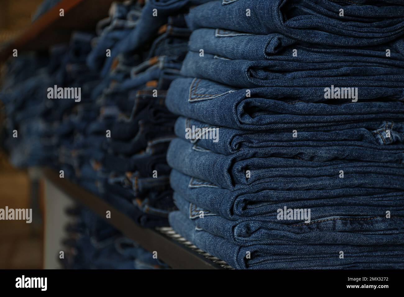 Collection of stylish jeans on shelf in shop Stock Photo - Alamy