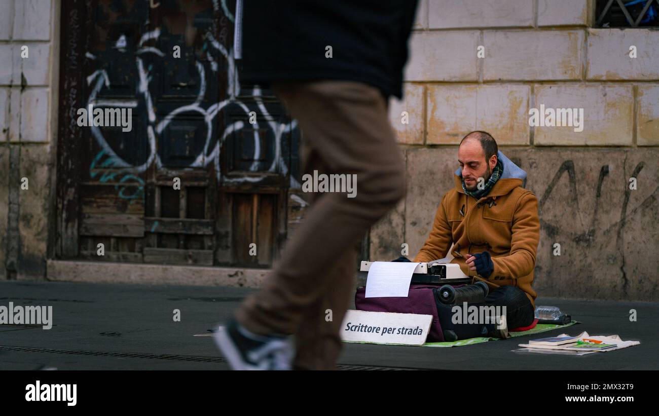 artist on the street sitting on the ground writing his stories and ...