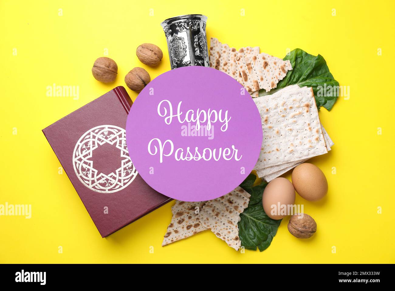 Symbolic Passover items and card on yellow background, flat lay. Pesah ...